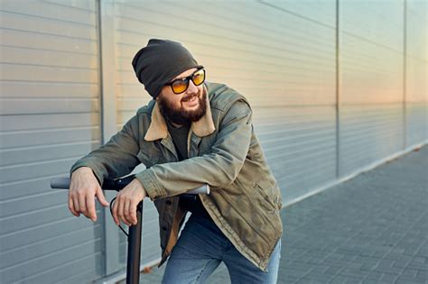 벽 근처 전기 스쿠터를 가진 남자 생태 교통 개념 전자 스쿠터에 포즈 선글라스에 세련된 남성 남자에 대한 스톡 사진 및 기타 이미지 Istock