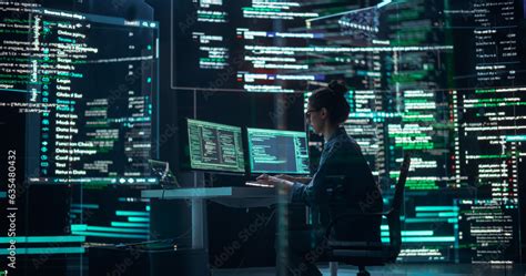 Professional Female Programmer Working In A Monitoring Control Room Surrounded By Big Screens