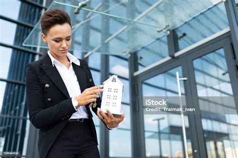 사무실 옷을 입은 백인 여성이 작은 백악관을 보유하고 사무실 건물 근처에서 동료를 기다립니다 개념에 대한 스톡 사진 및 기타 이미지 Istock