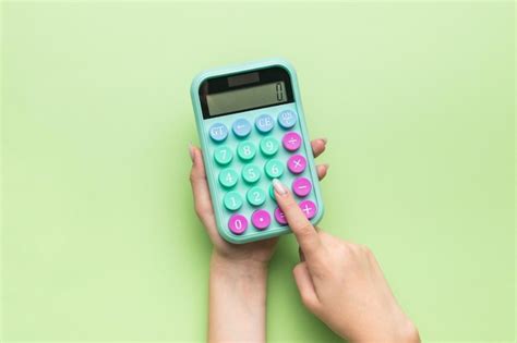 Premium Photo The Girls Hands Do Calculations On A Calculator On A Green Background A Device