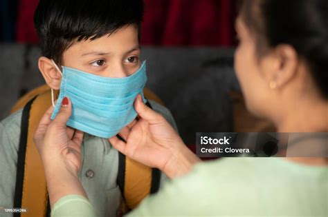 어머니는 아들에게 보호 얼굴 마스크를 착용하고 학교에 갈 준비를합니다 2명에 대한 스톡 사진 및 기타 이미지 2명 30