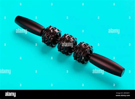 Black Bumpy Foam Body Massage Roller On A Blue Background For The