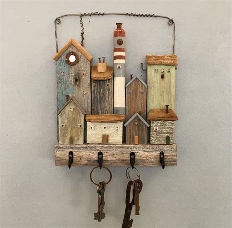 There Is A Wooden Wall Hanging With Houses And Key Holders On The Hook Along With Two Keys