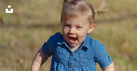 파란 셔츠를 입은 어린 소녀가 풀밭을 걷고 있다 사진 Unsplash의 무료 데님 이미지