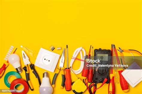 복사 공간이 있는 노란색 배경에 전기 장비 평면도 전기 공구 세트 멀티 미터 테스터 스크루 드라이버 커터 덕트 테이프 램프 줄자 및 와이어 플렛 누워 0명에 대한 스톡 사진