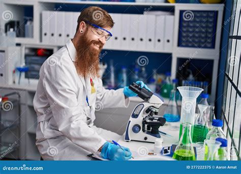 Young Redhead Man Scientist Using Microscope Writing Report Working At