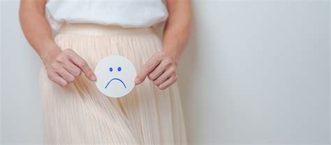 여자는 복부 위에 나쁘고 불행한 얼굴 종이를 들고 있다 난소 및 자궁경부암 자궁내막증 자궁적출술 자궁 생식 월경 불임 임신 및 성병 생리대에 대한 스톡 사진 및 기타 이미지