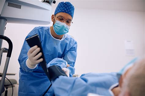 병원에서 수술을 위해 환자를 준비하는 동안 혈압계를 사용하는 의료 기술자 2명에 대한 스톡 사진 및 기타 이미지 2명