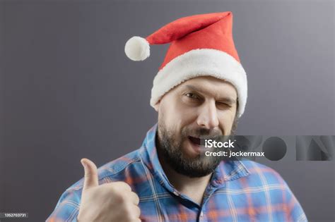 산타 모자를 쓴 수염을 기른 남자와 격자무늬 셔츠를 입은 남자가 윙크와 엄지손가락을 들고 있다 메리 크리스마스 포스터 12월에
