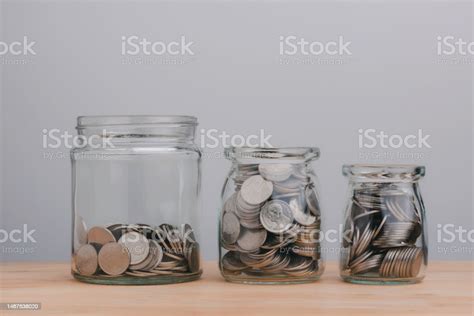 흰색 배경 위에 나무 테이블에 동전이 있는 세 가지 크기의 유리 항아리 금융 은행 사업 아이디어 투자 펀드 채권 배당금 및이자에 대한 돈 개념을 절약하십시오 0명에 대한
