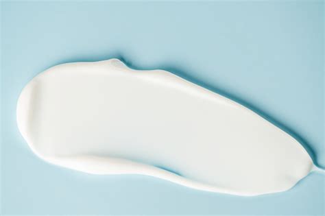 파스텔 블루 배경에 화이트 코스메틱 페이스 크림 또는 바디 로션 모이스처라이저 스트로크 크리미한 질감의 위생 스킨케어 제품 컬러 배경에 아름다움 얼굴 크림 얼룩 시계