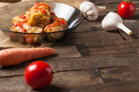 삶은 양배추 롤 의 한 부분 과 토마토 소스 의 쌀과 고기 가득 검은 유리 접시 에 야채 근처 Sacking 과 소박한 나무 테이블 갈색에 대한 스톡 사진 및 기타 이미지