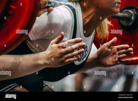 Female Powerlifter During Squat Powerlifting Coach Hands Are On Safety