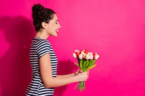 프로필 측 사진 흥분 긍정적 인 쾌활한 소녀 홀드 신선한 녹색 무리 튤립 받은 여성 의날 룩 을 즐길 선물 착용 트렌디 한 스타일 의상 밝은 색상 배경 위에 고립 갈색