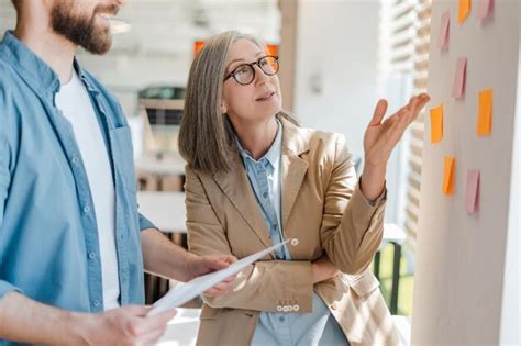 Premium Photo Scrum Master Using Sticky Notes Standing Near Planning Board In Modern Office