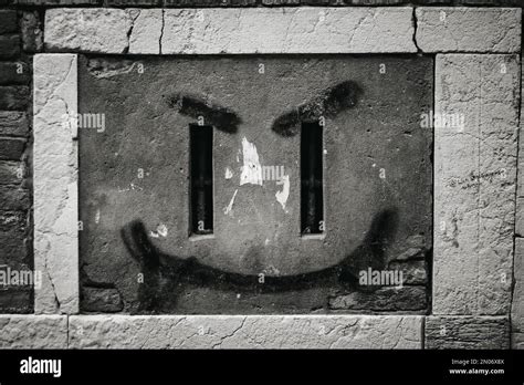 A Simple Graffiti Of A Smiling Face On A Street Wall Grayscale Stock