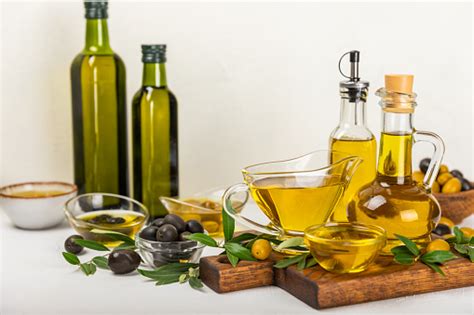 흰색 질감 배경에 병에 담긴 올리브 오일 올리브의 가지와 열매가 달린 기름 병 텍스트를 위한 위치입니다 복사 공간 식용유와 샐러드 드레싱 건강한 생활방식에 대한 스톡 사진