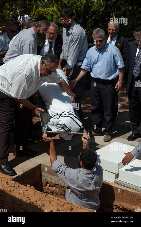 Orthodox Jewish Pallbearers Lower The Shroud Covered Body Of Renowned