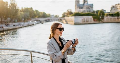 파리의 일몰 동안 보트에서 노트르담 대성당과 함께 강변에서 아름다운 풍경을 즐기는 젊은 여성 관광객 사진 Unsplash의 수송 이미지