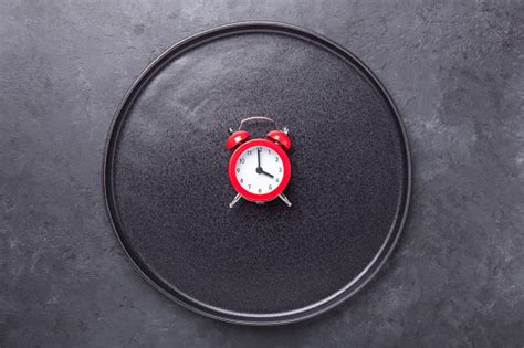 어두운 돌 배경에 빨간색 알람 시계와 빈 검은 색 세라믹 플레이트 간헐적 단식 개념 16에 대한 스톡 사진 및 기타 이미지 16 8 간헐적 단식 Istock