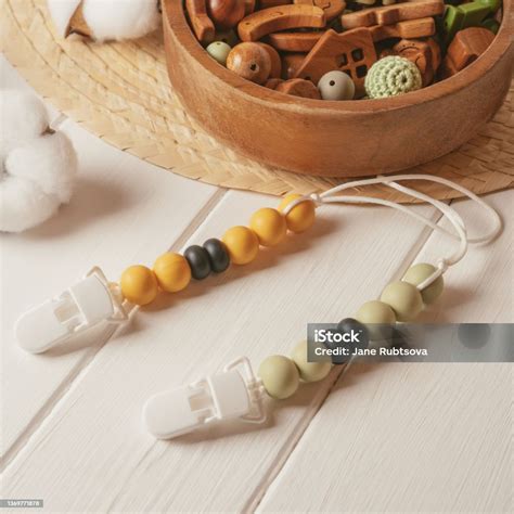 흰색 플라스틱 옷핀흰색 검은색 주황색 나무 구슬이 흰색 끈에 나무 그릇 근처의 베이비 젖꼭지를 위한 흰색 끈 젖꼭지에 대한 스톡 사진 및 기타 이미지 Istock