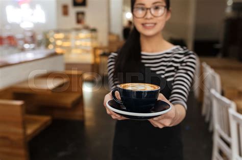 Asian Barmaid Extends The Cup Of Coffee Stock Image Colourbox