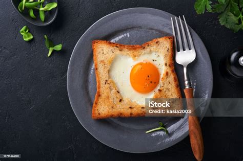 발렌타인 데이에 아침 식사 검은 색 배경에 심장과 신선한 야채의 모양에 계란과 빵 튀김 사랑하는 사람을 위한 놀라움과 함께 아침 식사 맨 위 보기입니다 모의 0명에 대한