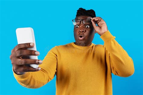 Amazing Offer Portrait Of Shocked Black Man Looking At Smartphone