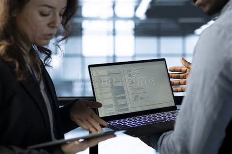 Software Developers In Data Center Workspace Use Laptop To Calibrate Energy Usage Stock Image