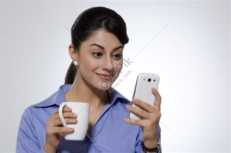 회색 배경 위에 커피잔을 들고 스마트폰으로 문자 메시지를 읽으면서 웃고 있는 사업가 Photo 사진 무료 다운로드 Lovepik