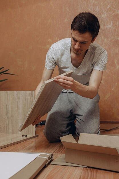 Premium Photo Man Assembling Furniture While Sitting On Floor With