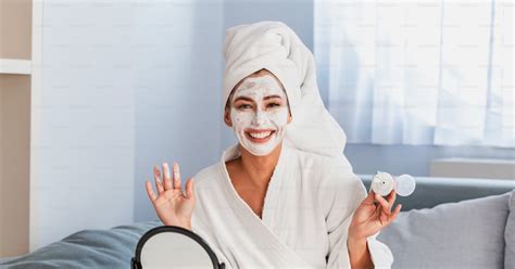 집에서 얼굴에 클렌징 마스크를 쓴 젊은 여성 피부 관리 뷰티 마스크를 착용하는 여자 닫힙니다 매우 아름다운 거울을 보고 있는 얼굴에 뷰티 마스크를 쓴 소녀의