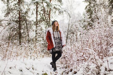 겨울 숲에서 모피와 모자를 쓴 빨간 재킷을 입은 빨간 머리 여자 휴가를 즐기는 예쁜 여자 자연의 소녀 행복을 느껴보세요 흰