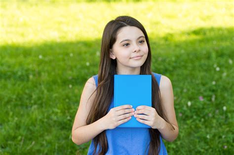 하루에 예약하면 지루함을 멀리 합니다 어린 소녀는 야외에서 책을 들고 있습니다 여름 날에 작은 독자 도서관 책 판타지와 소설 문학과 시 독서 습관 좋은 책에서 길을 잃기