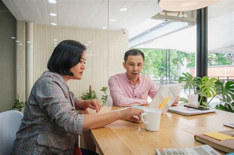 두 명의 아시아인 동료가 함께 작업하고 현대 사무실에서 새로운 프로젝트에 대해 논의합니다 2명에 대한 스톡 사진 및 기타 이미지 2명 40 49세 45 49세