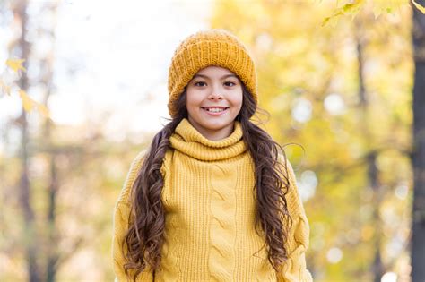 모자는 따뜻하게 유지합니다 아이는 따뜻한 부드러운 니트 모자를 착용합니다 따뜻한 모직 액세서리 소녀 긴 머리 행복한 얼굴 자연 배경 이번 가을에 가장 따뜻하게 지내십시오