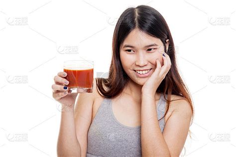 美丽健康的亚洲女孩喜欢番茄汁。