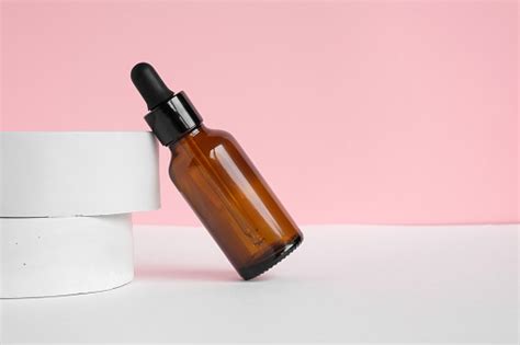 호박색 유리 점적기 화장품 병 흰색 연단 자연 스킨 케어 Spa 뷰티 제품 디자인 분홍색 배경에 미네랄 유기농 오일 모형 기름진