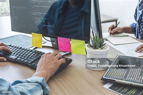 코드 작성 및 데이터 코드 기술 입력 회사에서 데스크톱 컴퓨터에서 개발하는 소프트웨어에서 웹 사이트 프로젝트에 협력하는 두 명의 전문 프로그래머 개발에 대한 스톡 사진 및