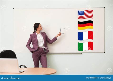 Foreign Languages Teacher Near Whiteboard With Different Flags In