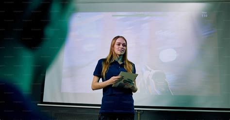 새로운 네트워크 비디오 게임의 젊고 자신감 있는 여성 개발자로 프레젠테이션 중 대형 화면 옆에 디지털 태블릿이 서 있다 사진 Unsplash의 성인 이미지