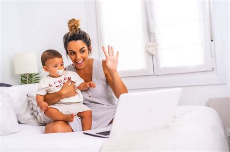 Jeune Mère Avec Son Fils Dans La Chambre Au dessus Du Lit Faisant Un Appel Vidéo Photo Premium