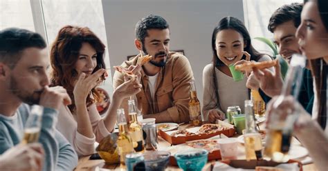 캐주얼 웨어를 입은 젊은이들이 실내에서 디너 파티를 하는 동안 피자를 먹고 웃고 있다 사진 Unsplash의 우크라이나 이미지