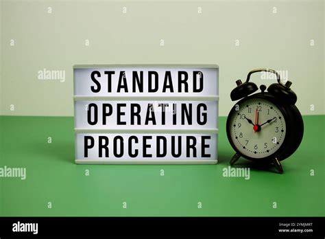 Standard Operating Procedure Text On Led Lightbox With Alarm Clock On Green Background Stock