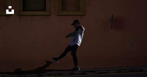 흰 셔츠와 검은 바지를 입은 남자가 검은 스케이트보드에 뛰어든다 사진 Unsplash의 무료 남자 이미지