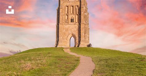 주황색과 회색 흐린 하늘 아래 푸른 잔디밭에 갈색 벽돌 건물 사진 Unsplash의 무료 길 이미지