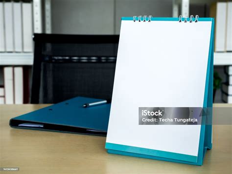 흰색 빈 바탕 화면 플립 탑 캘린더 템플릿 세로 스타일은 기업 디자인을위한 목재 테이블의 문서 폴더 근처에 있습니다 책상 서있는 나선형 테이블 달력 모형 연도 및 월 계획