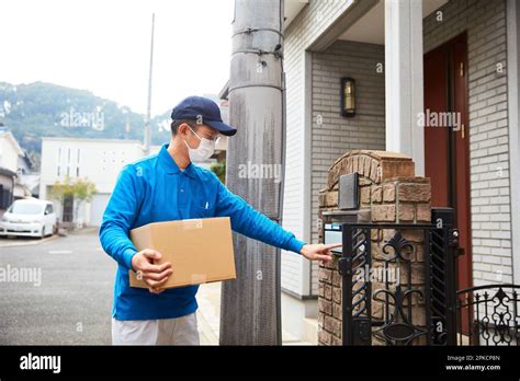 Male Delivery Man Wearing Mask Ringing Intercom Stock Photo Alamy