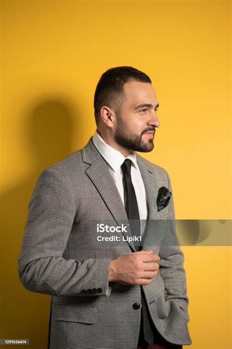 한쪽 손으로 회색 양복을 입은 잘생긴 미소 젊은 남자 노란색 배경에 옆으로 고립 된 반쪽을 들어 올려 경영자에 대한 스톡 사진