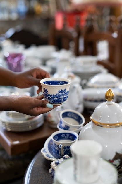 골동품 가게에서 컵을 들고 측면 보기 손 무료 사진